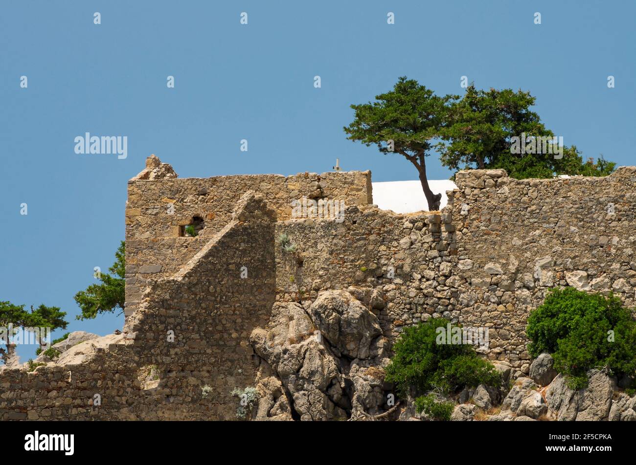 Fortress wall of the medieval Monolithos castle illuminated by the sun ...