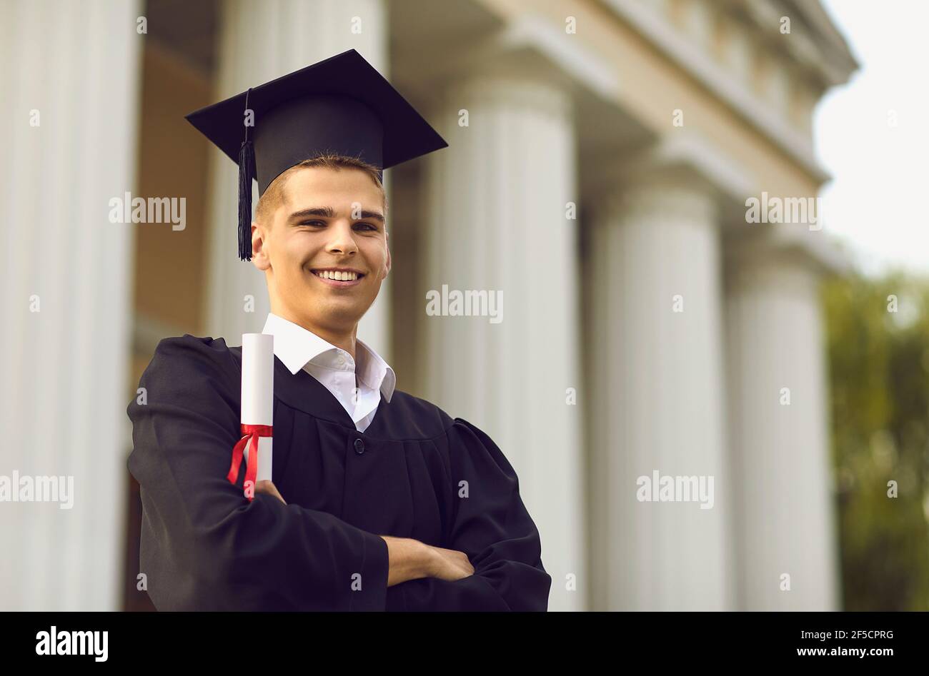 Happy male college graduate student in mortatboard holding diploma near ...