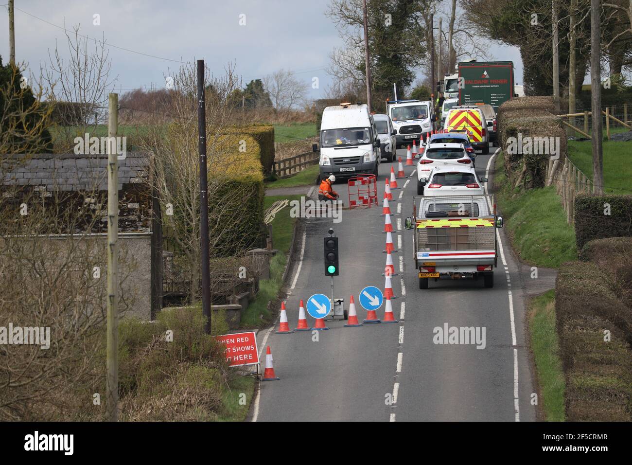Workmen install a fiber-optic cable under a rural road outside Lisburn ...