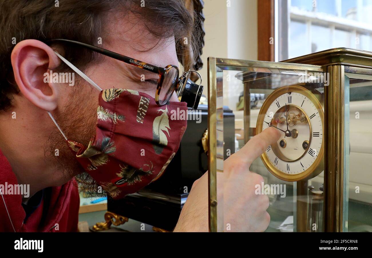 Clock conservation student Mikey Martin adjusts clocks in the clock ...