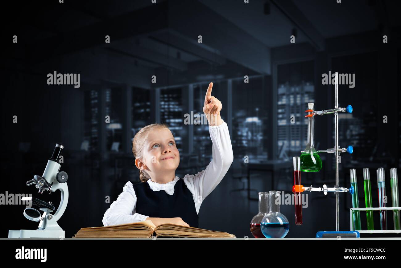 Little girl scientist sitting at desk Stock Photo - Alamy