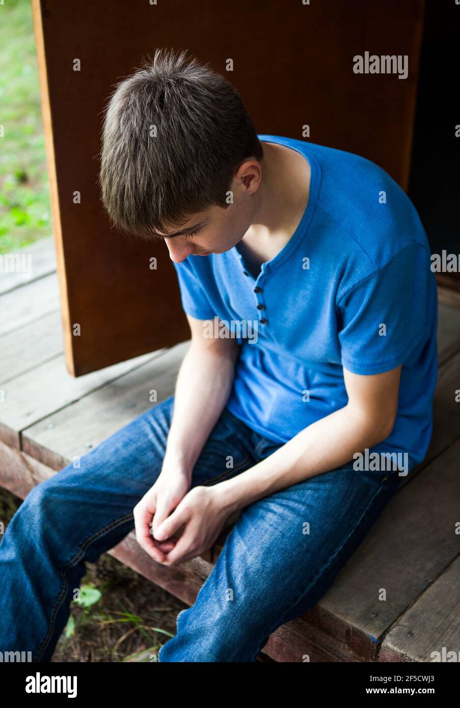 Sad Young Man sit near the House outdoor Stock Photo - Alamy