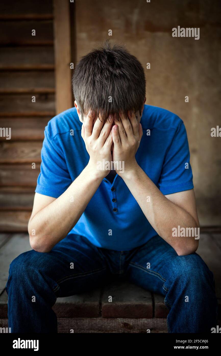 Sad Young Man sit near the House outdoor Stock Photo - Alamy