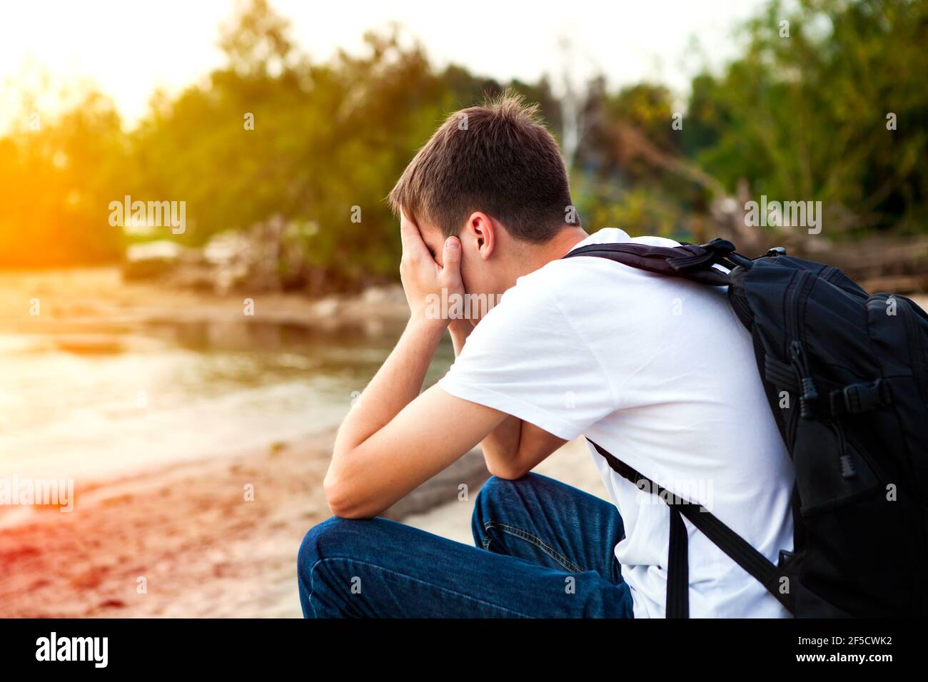 Sad Young Man with Backpack at the Seaside Stock Photo - Alamy