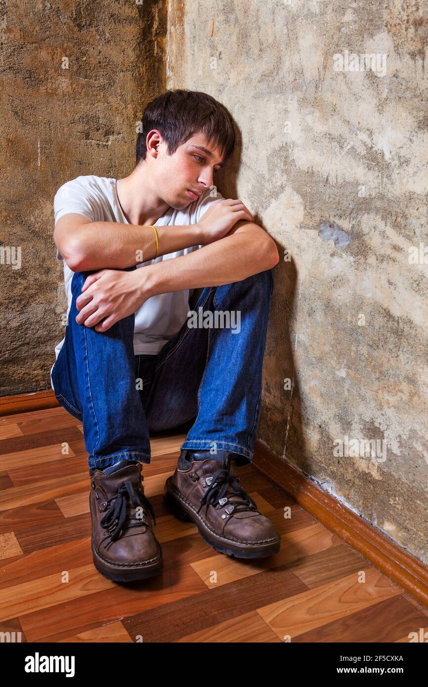 Sad Young Man on the Floor by the Old Wall Stock Photo - Alamy