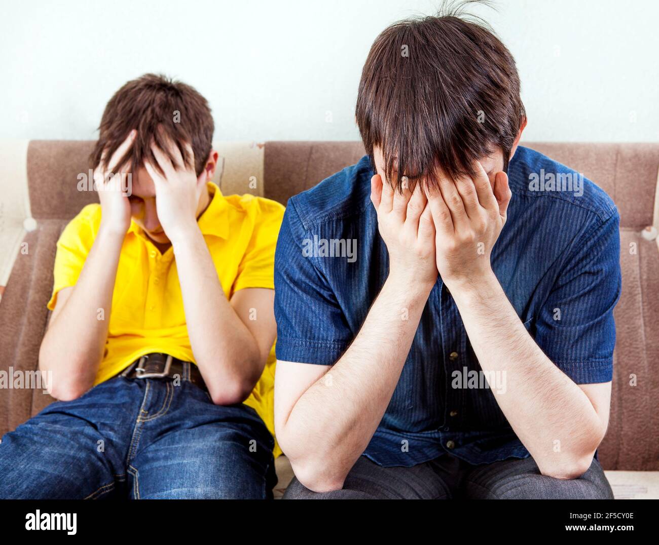 Two Sad Men on the Couch in the Room Stock Photo - Alamy