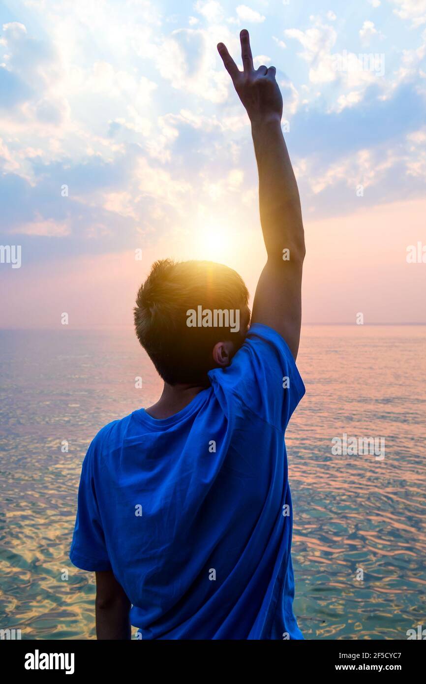 Happy Man with Victory Gesture on the Sea Background Stock Photo - Alamy