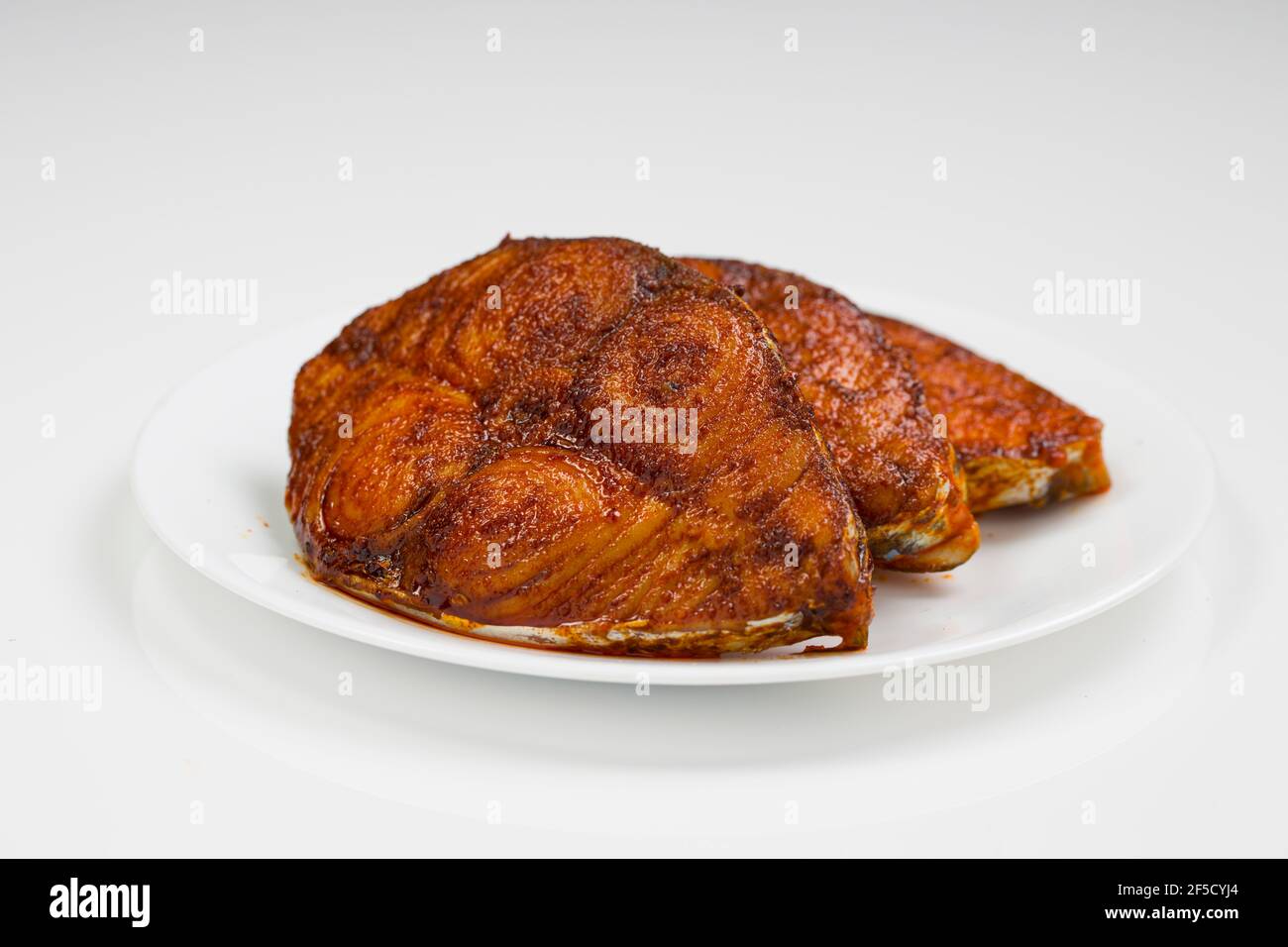 Seer fish fry arranged beautifully on awhite ceramic plate with white ...