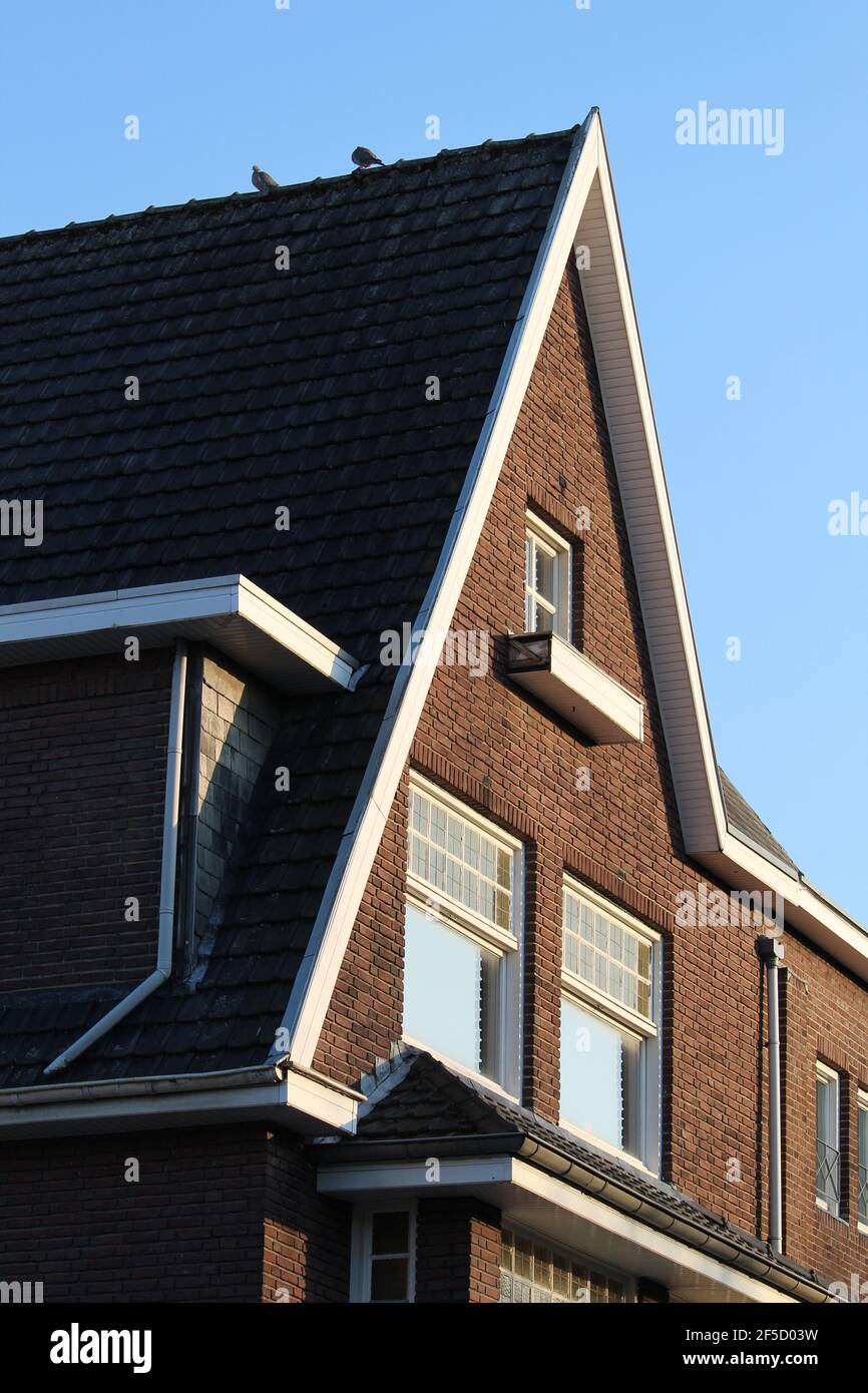 Brick house with shingles roof Stock Photo - Alamy