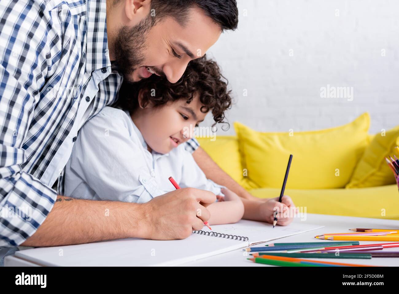 cheerful muslim father and son drawing in sketchbook with pencils Stock ...