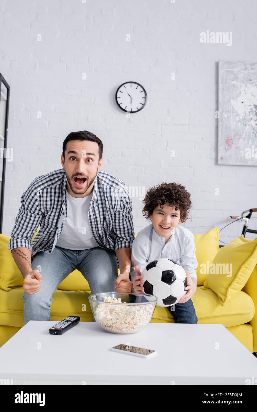 amazed muslim man showing win gesture while watching football match ...
