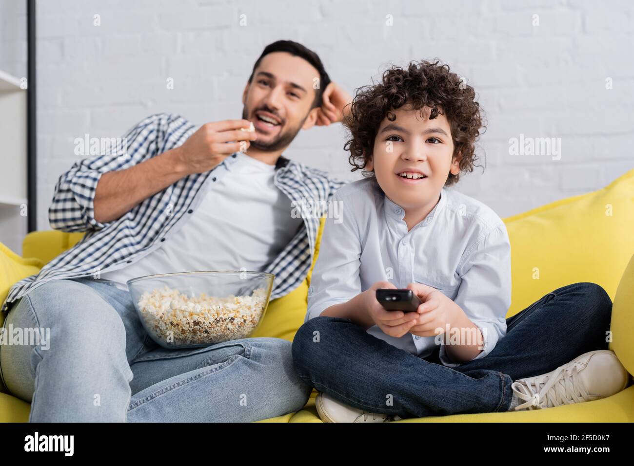 cheerful arabian father and son watching comedy movie at home Stock ...