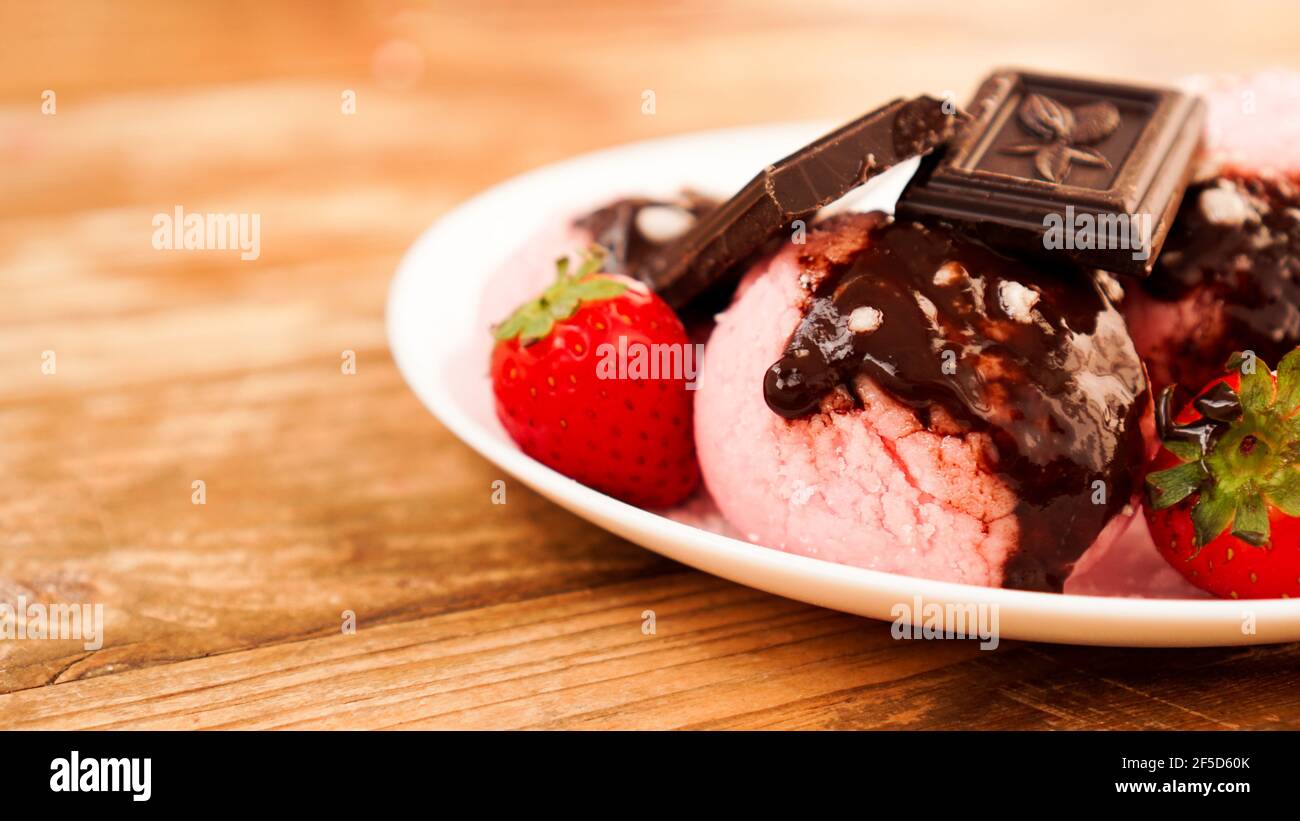 Homemade strawberry ice cream on white plate on a rustic background ...
