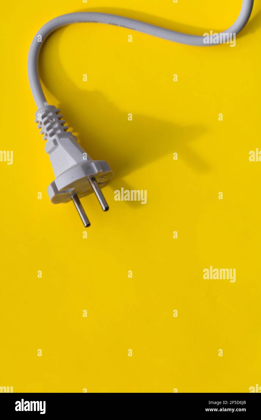 white plug on yellow background Stock Photo - Alamy