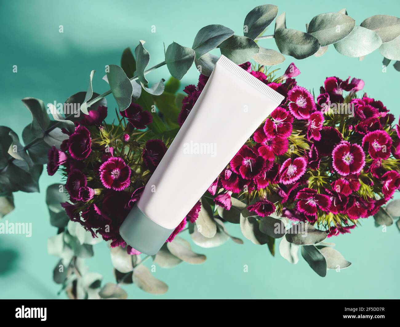 White generic cream tube on botanical background with pink flowers ...