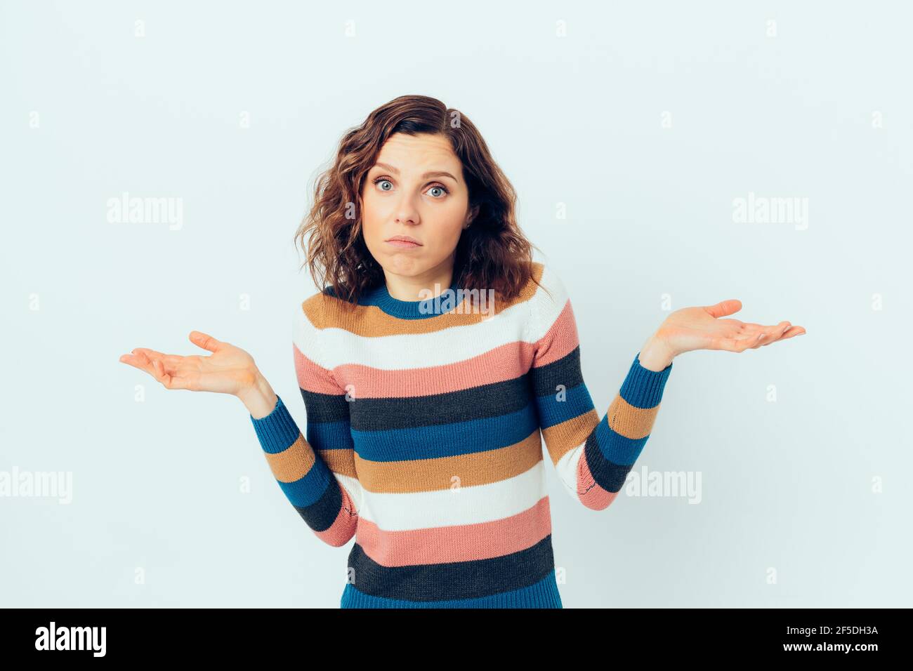 Young woman with confused and sad expression stands indifferently ...