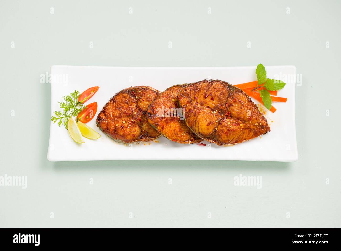 Seer fish fry arranged beautifully and garnished with onion, lemon and ...