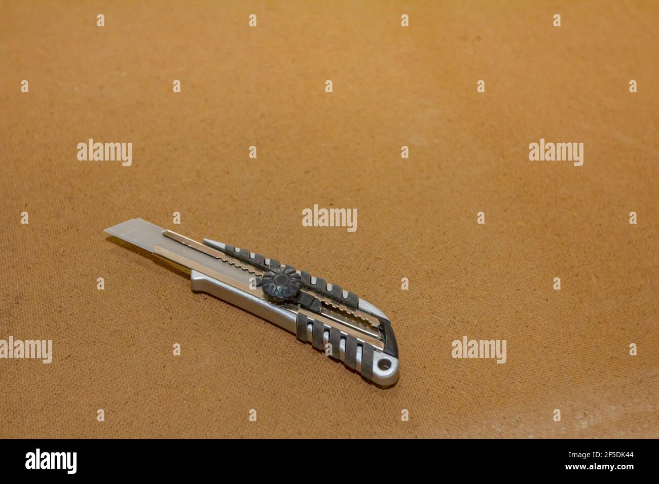 Scalpel, cutter tool with an open blade placed on the plywood in ...