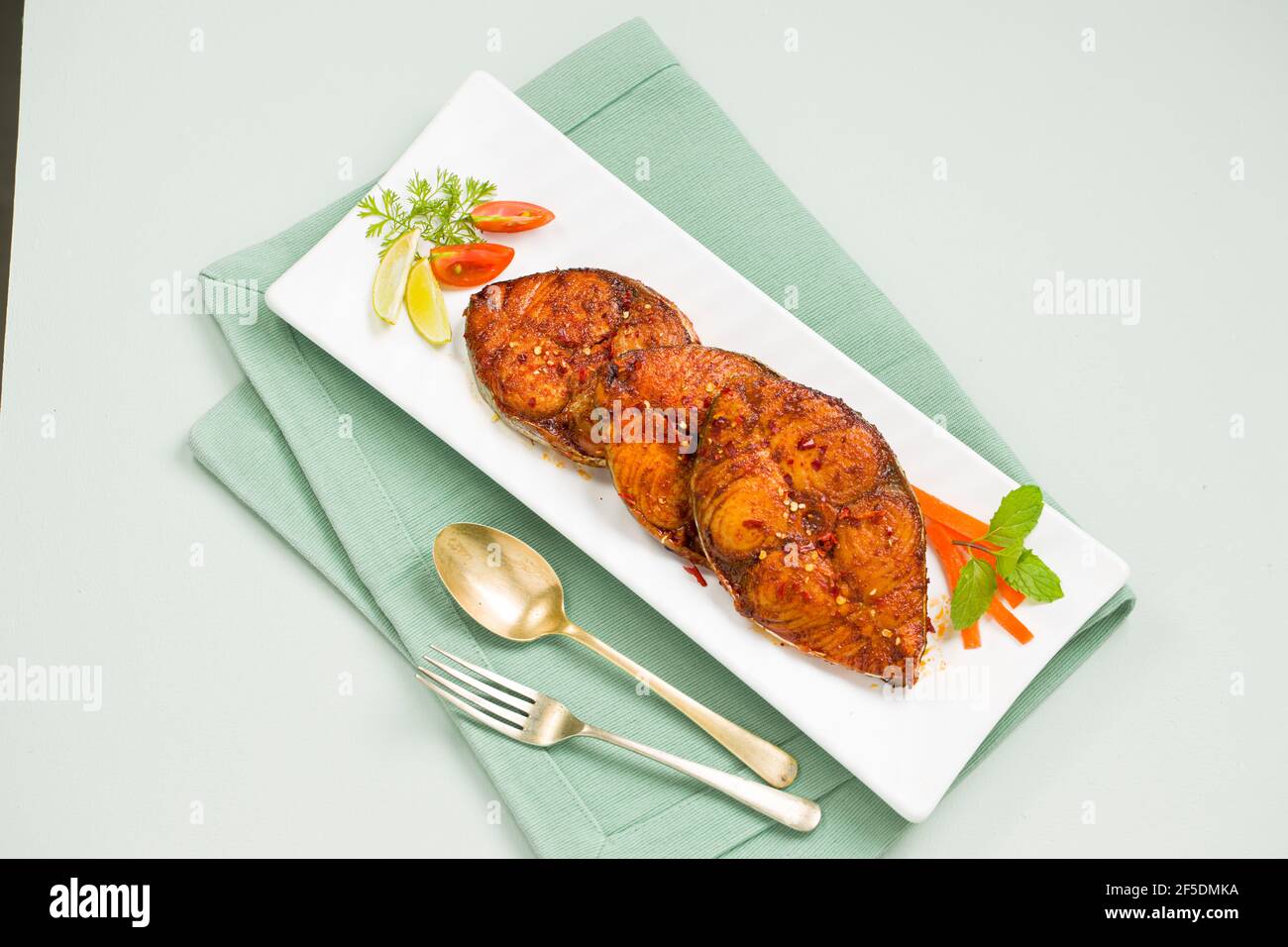 Seer fish fry arranged beautifully and garnished with onion, lemon and ...