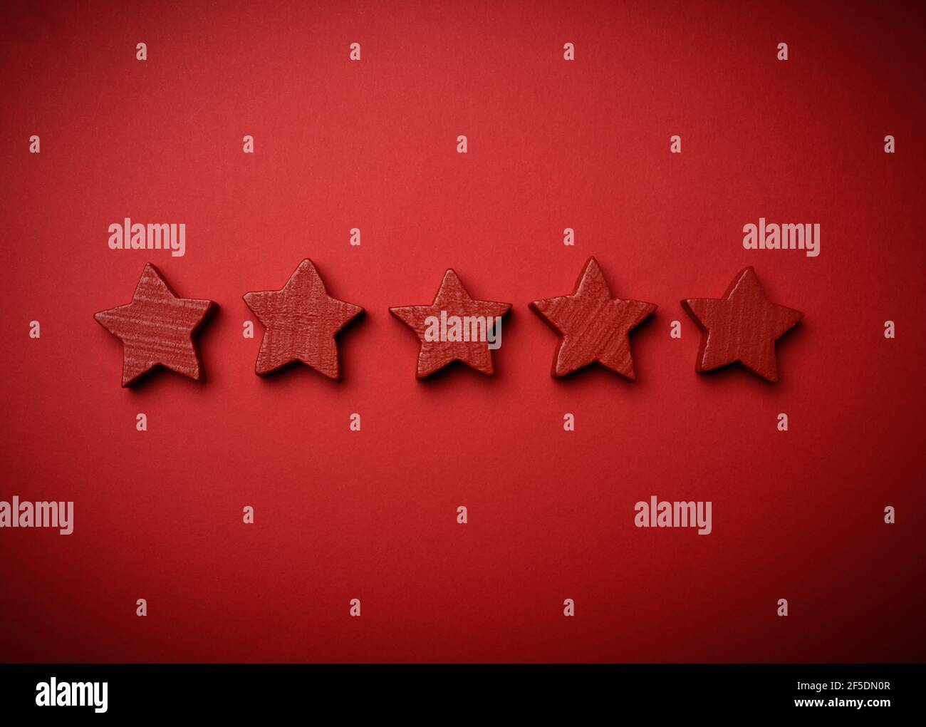 five red wooden stars on a red background, high score, rating Stock ...
