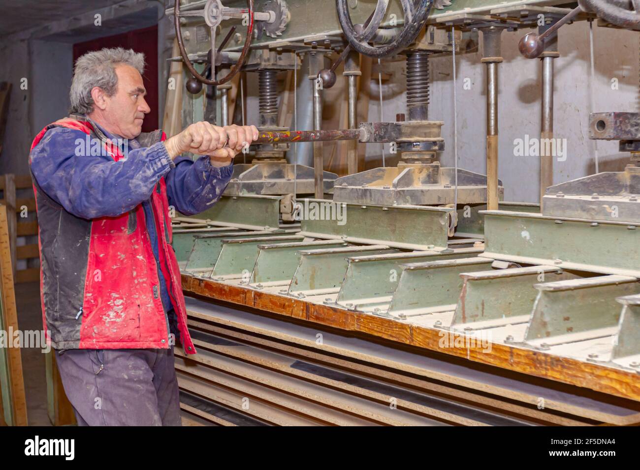 Worker is squeezing the press machine turning mechanism with metal ...
