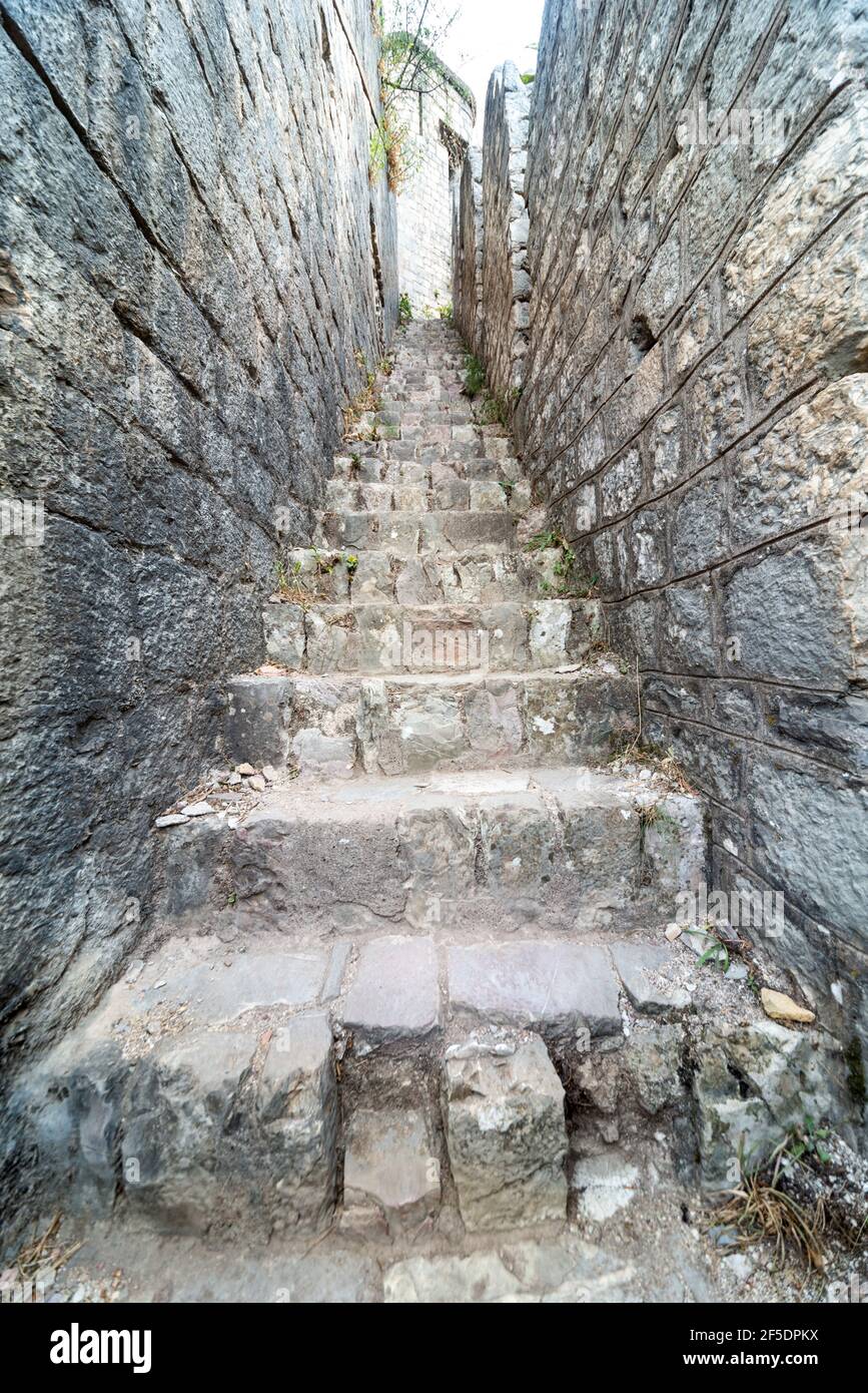 Steep crumbling steps between ancient historic 16th century walls of ...