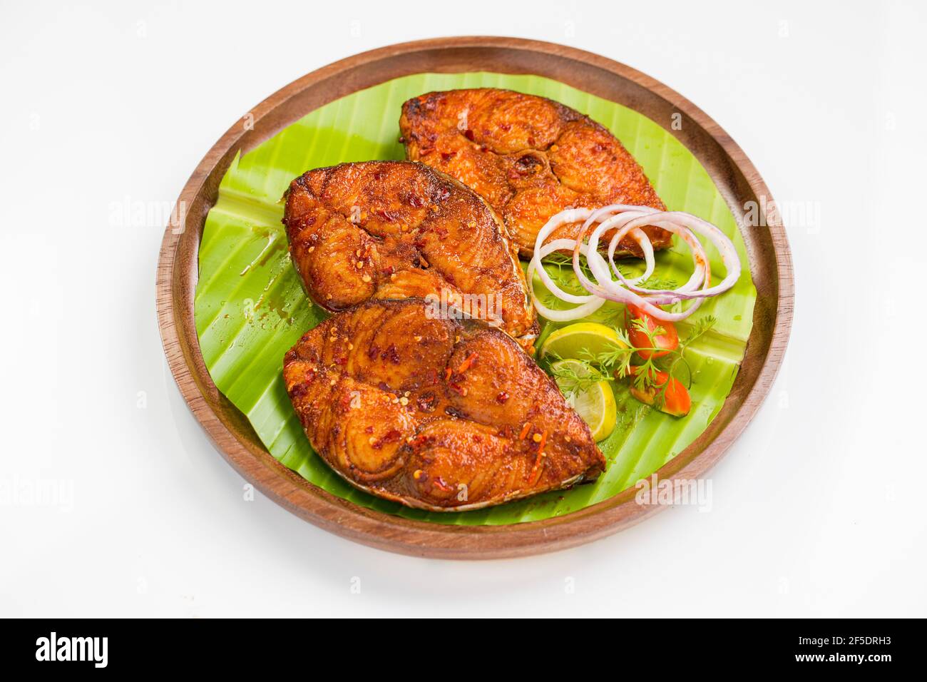 Seer fish fry arranged beautifully and garnished with onion, lemon and ...