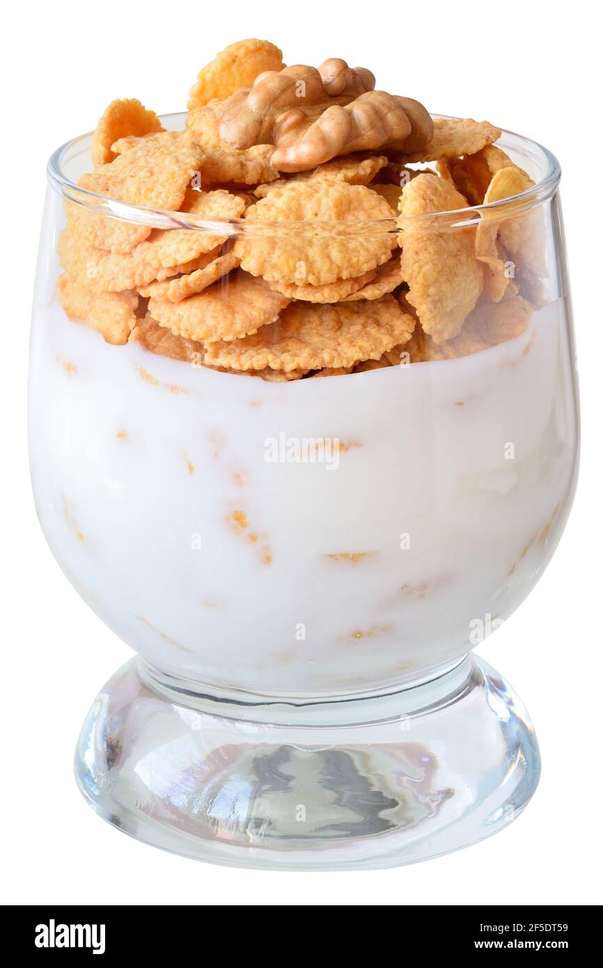 Yogurt with cornflakes and walnuts in a glass goblet isolated on a ...