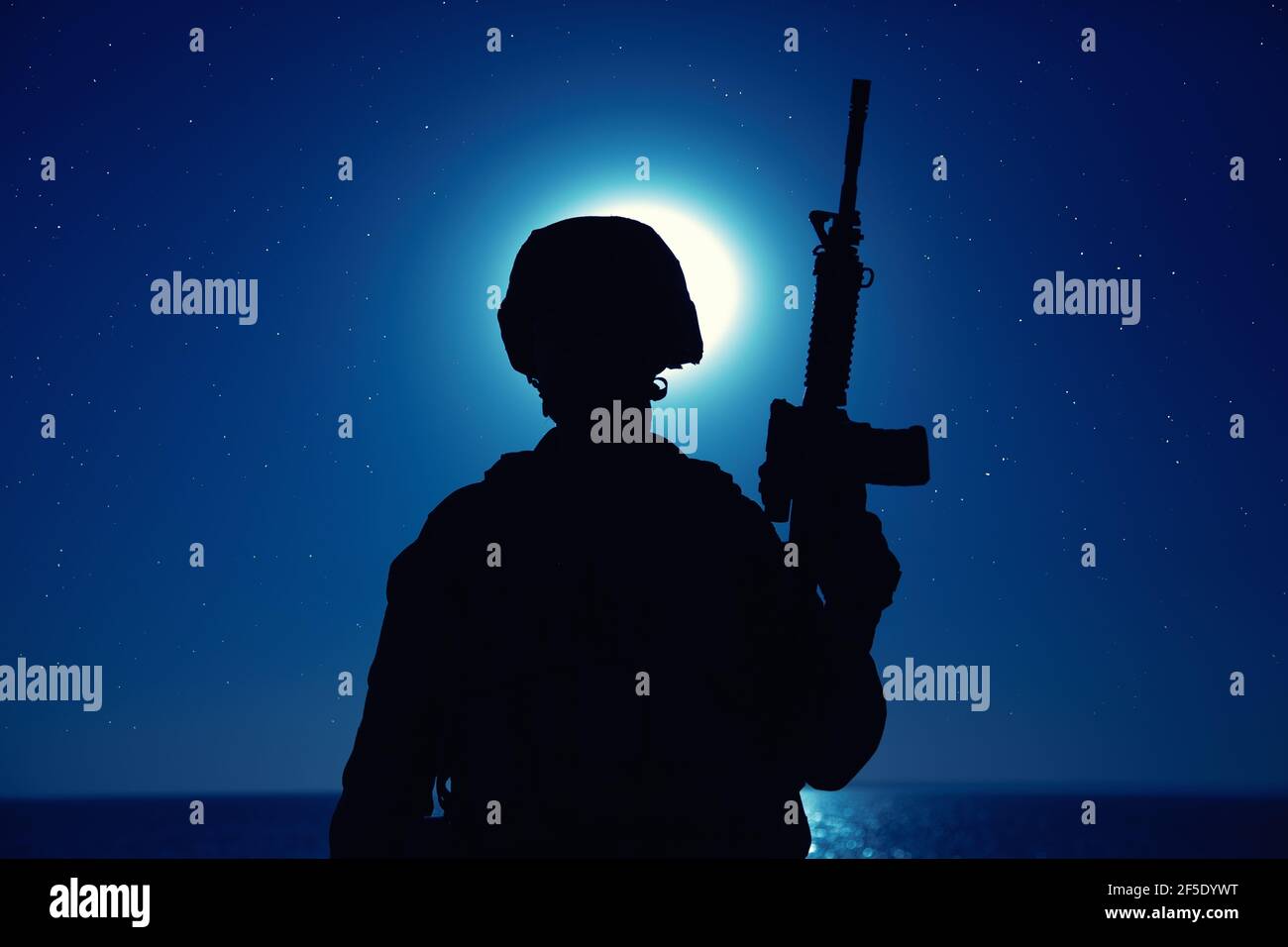 Silhouette of army soldier standing with service rifle in hand on ...