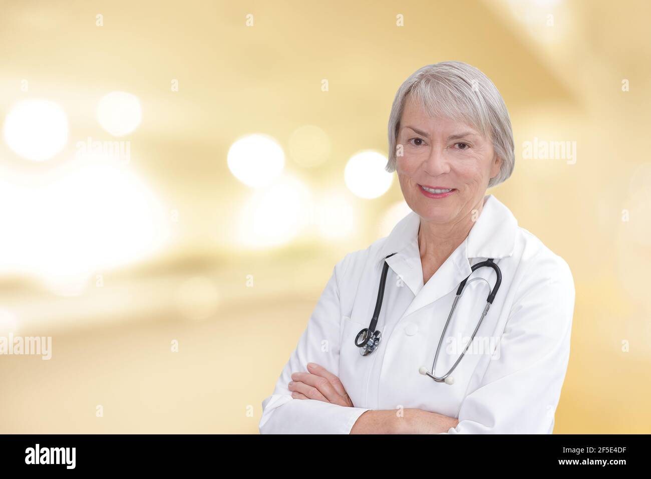 Portrait of a smiling medical director with stethoscope, blurred yellow ...