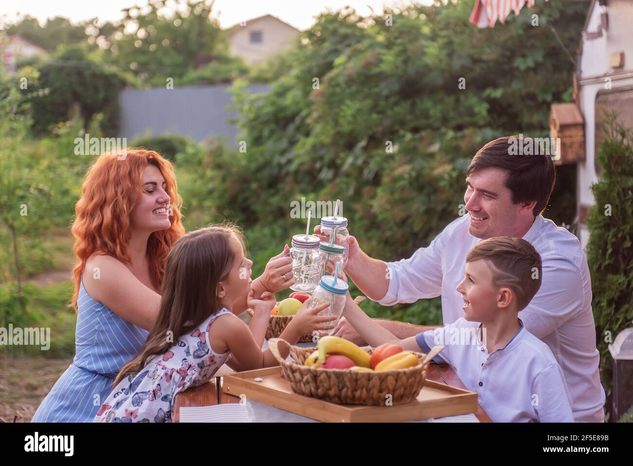 Family sitting at picnic table hi-res stock photography and images - Alamy