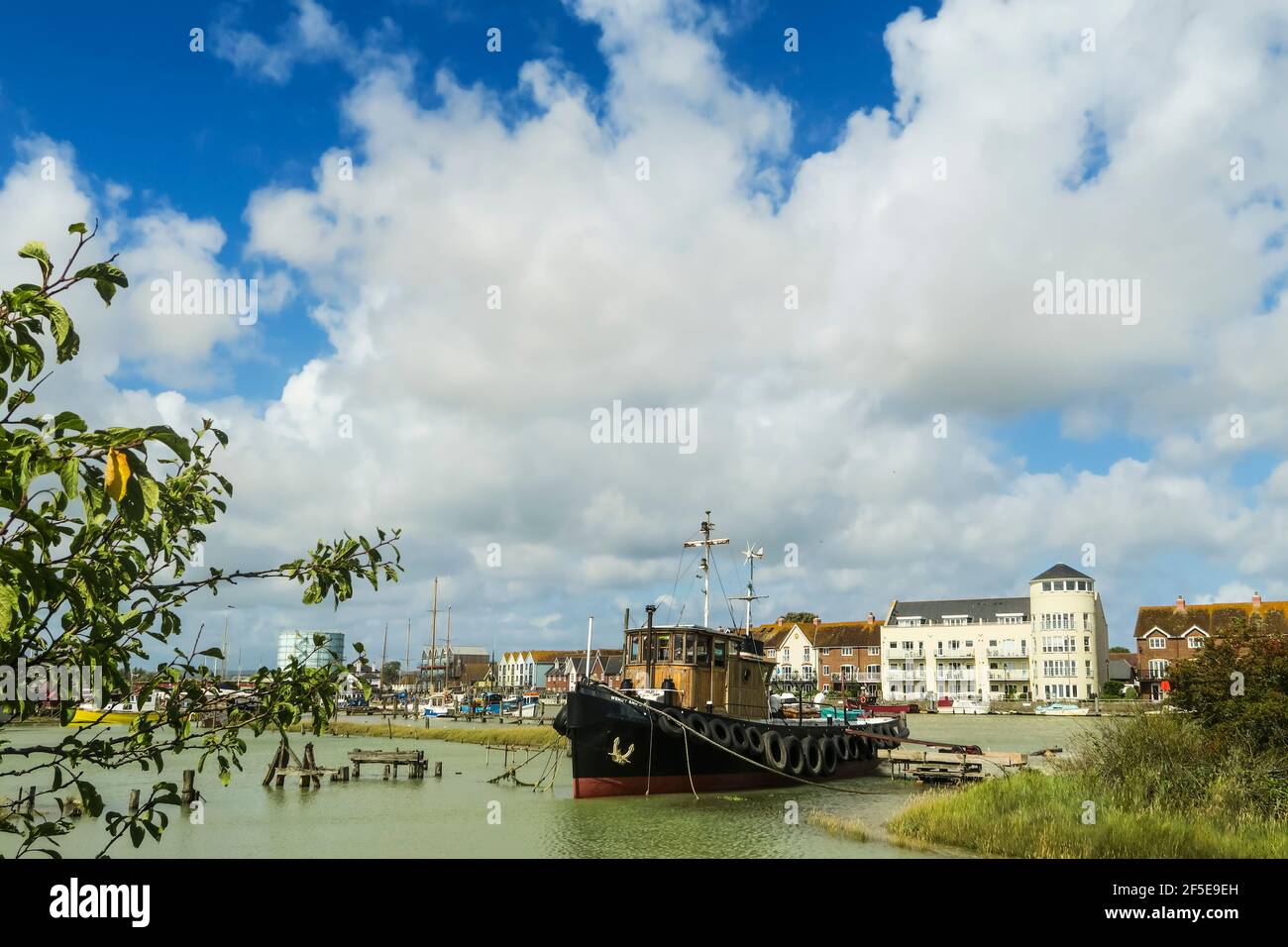 Fishing boat moored on the River Arun with Littlehampton town centre ...