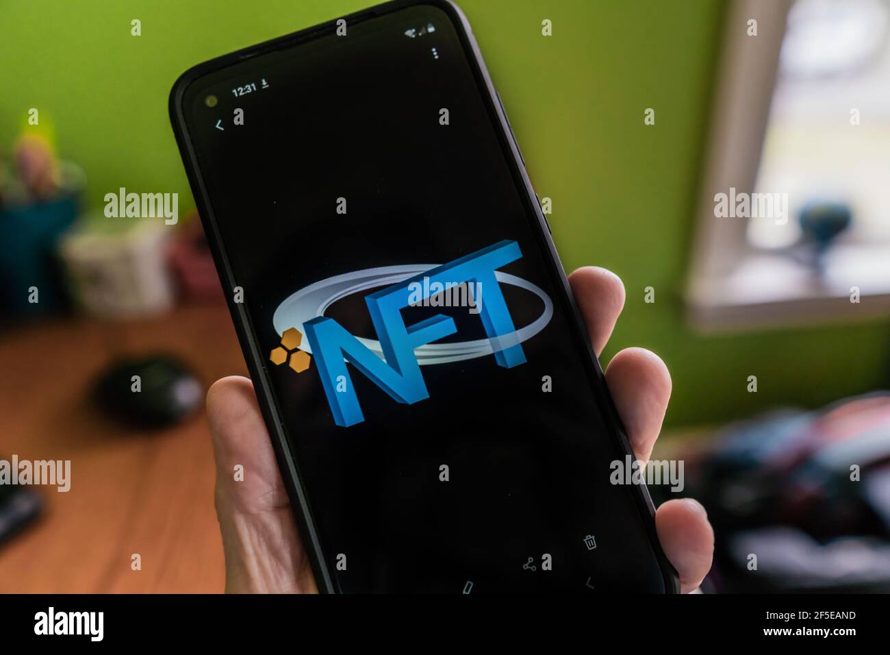 Andover, MA, US-March 24, 2021: Person holding phone with NFT logo on ...