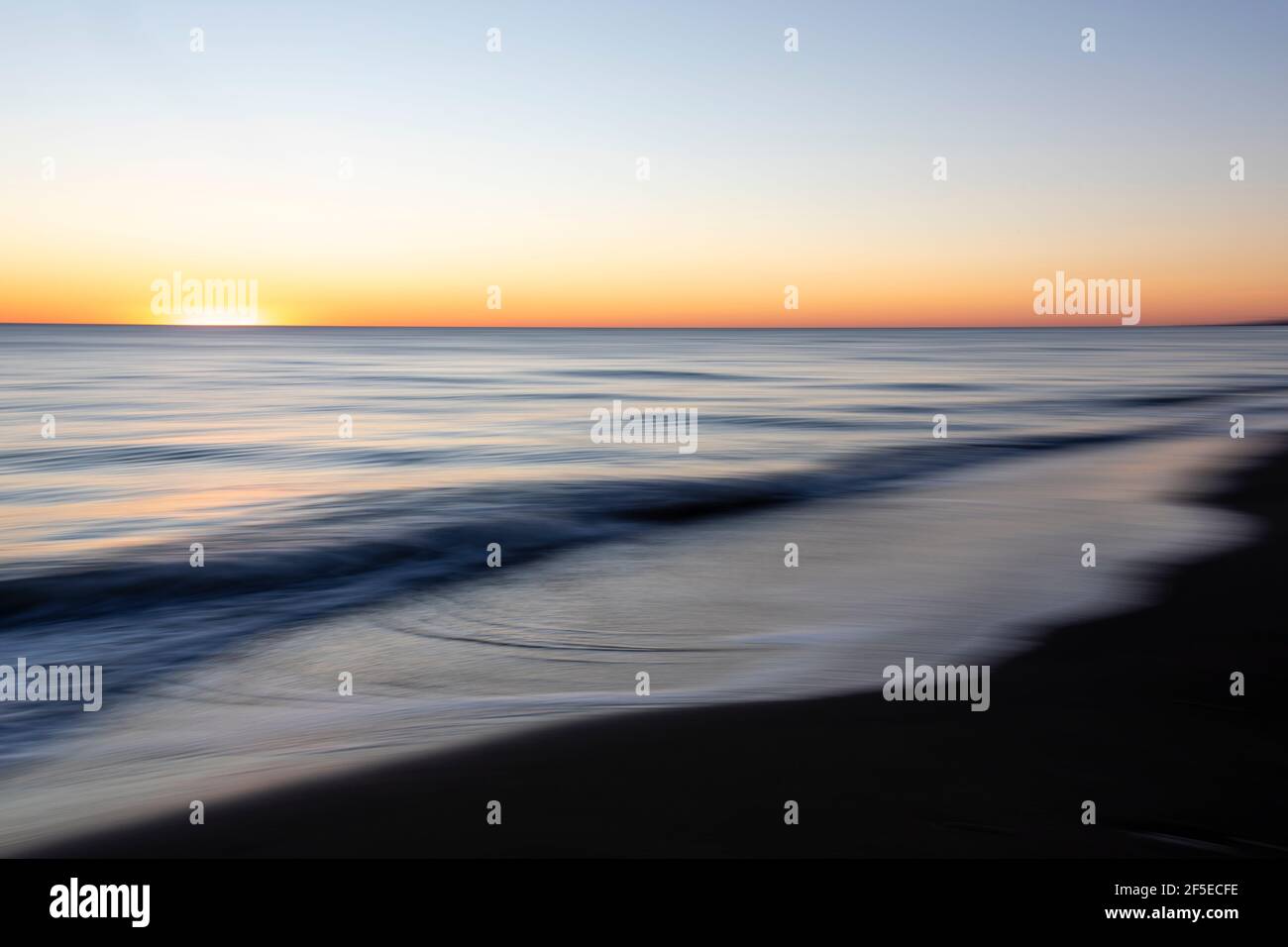 the waves of the sea during the sunset Stock Photo - Alamy