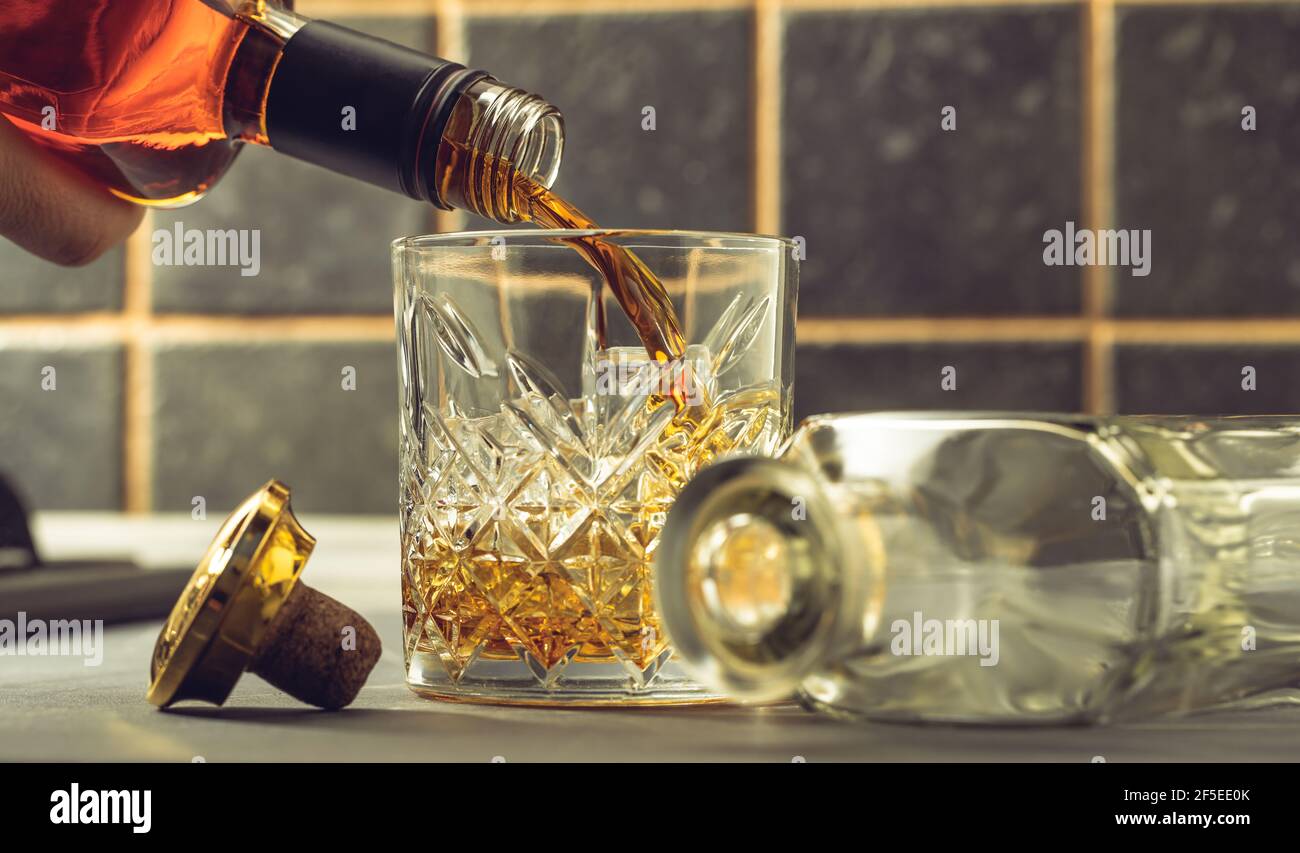 whiskey is poured into a glass from bottle Stock Photo - Alamy