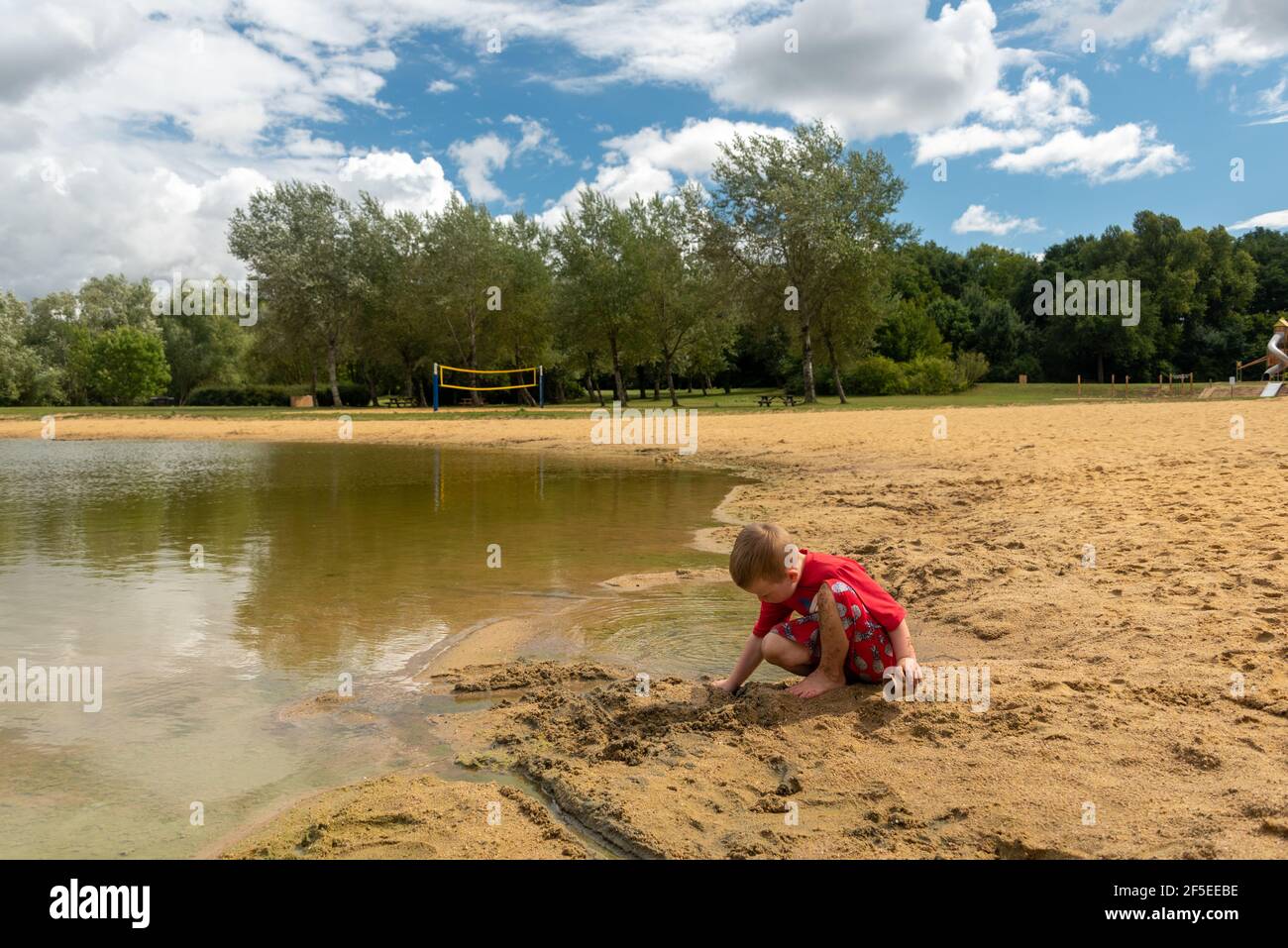 A young boy playing in the sand at a man made beach at Rille in the ...
