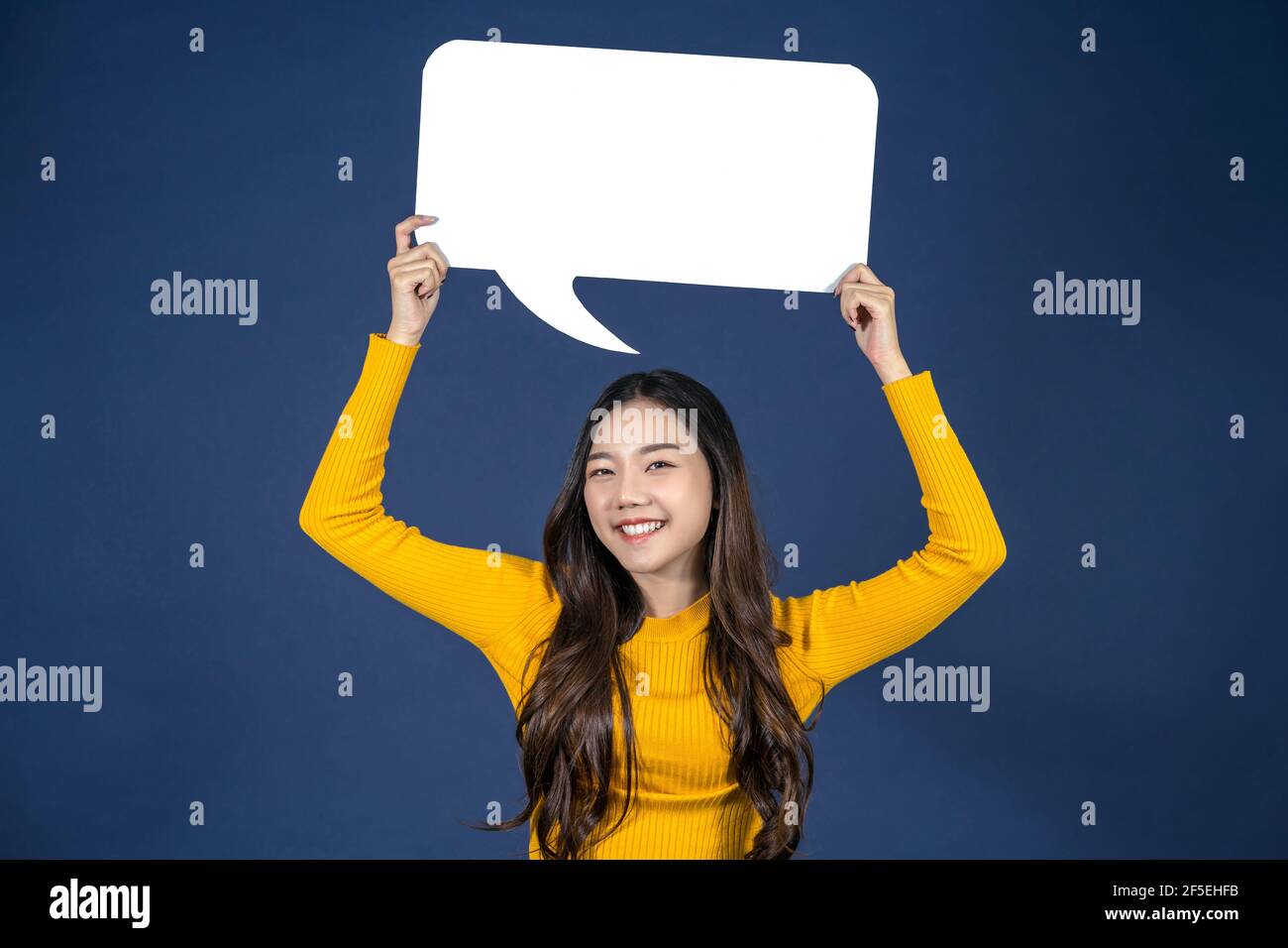 Happy young smiling Asian woman holding copy space empty message ...
