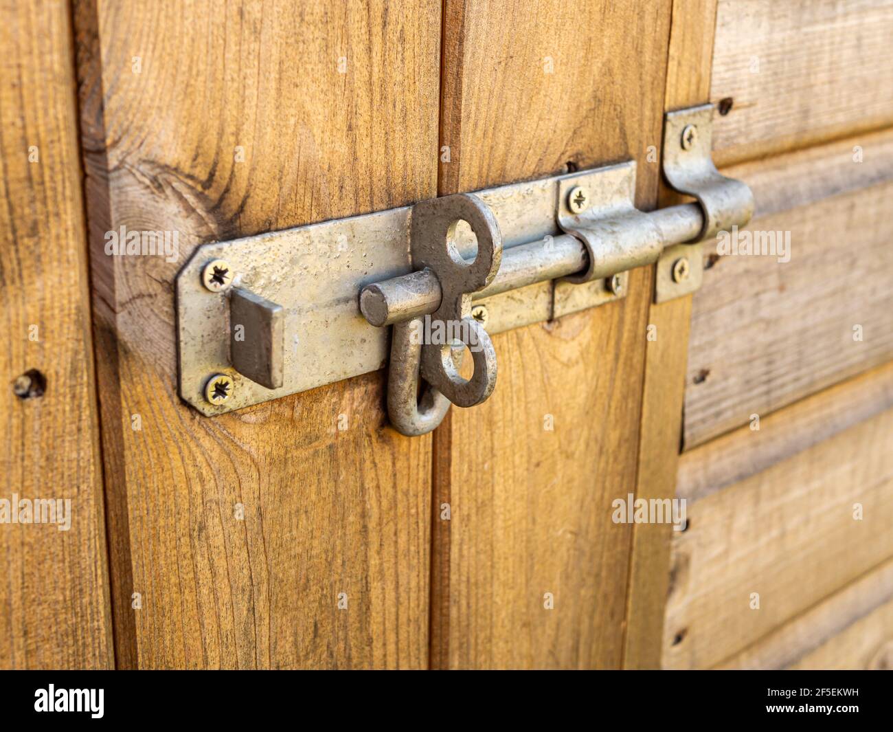Galvanised bolt locking shed door Stock Photo - Alamy