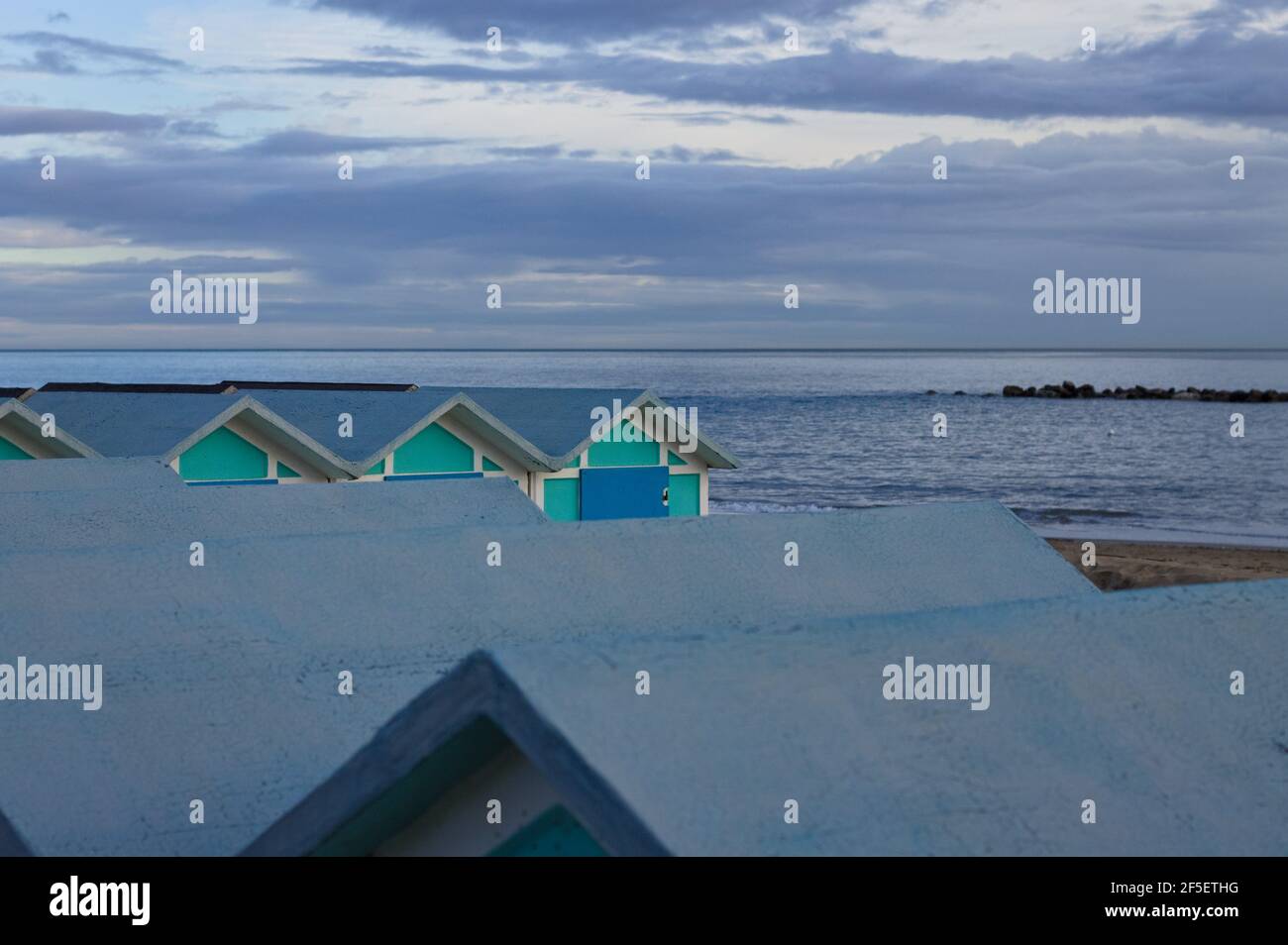 A series of blue beach huts on the Mediterranean coast in the evening ...