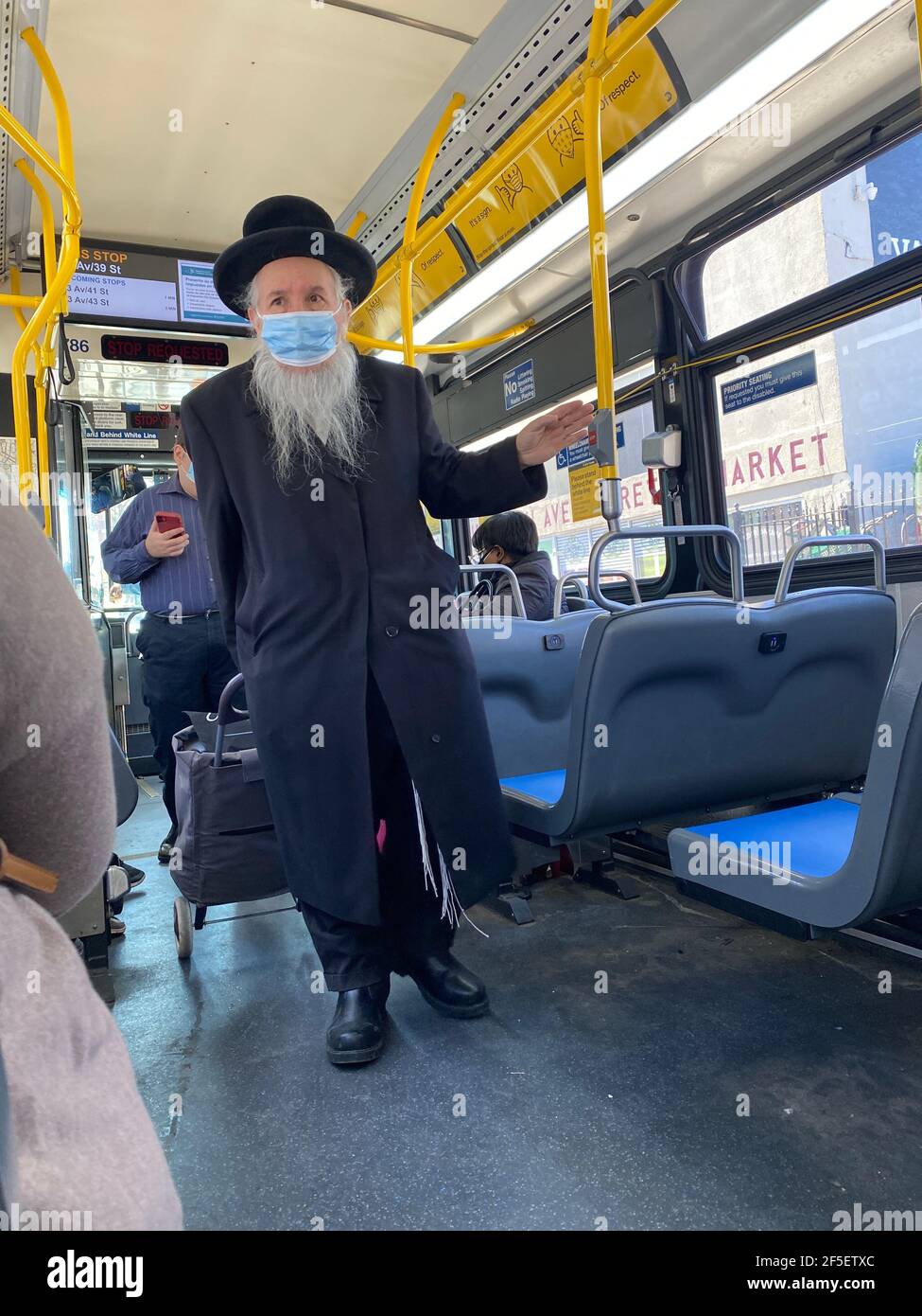 Elderly Orthodox Jewish man entering a local bus on 13th Avenue, the ...