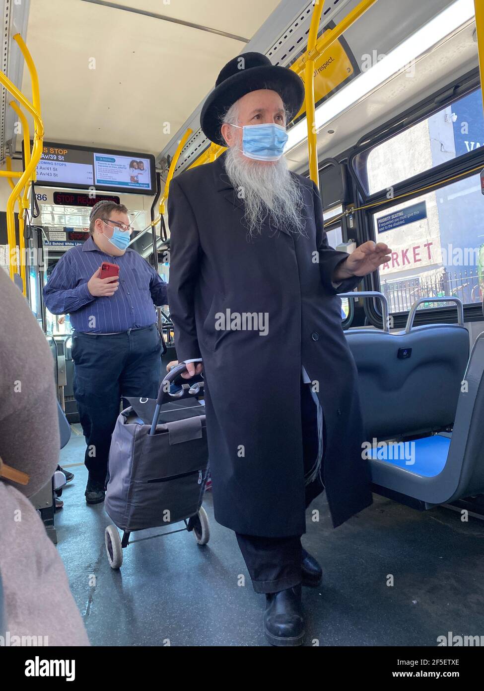 Elderly Orthodox Jewish man entering a local bus on 13th Avenue, the ...
