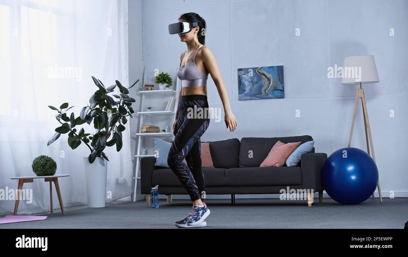 happy young woman in sportswear and vr headset working out at home ...