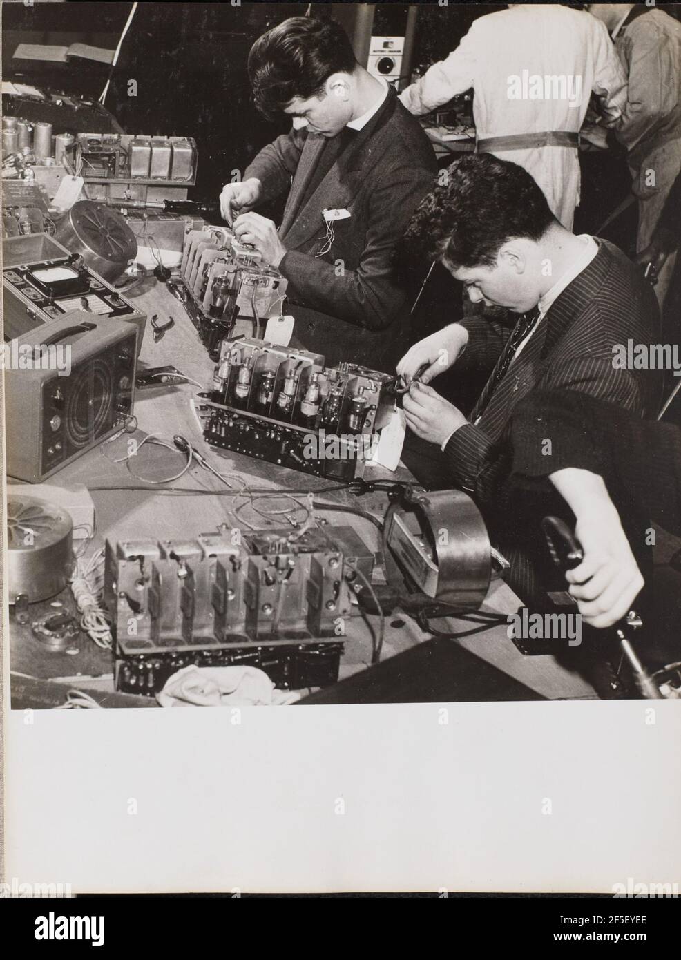 Two young men wearing blazers work on radios. Arnold Eagle (American ...