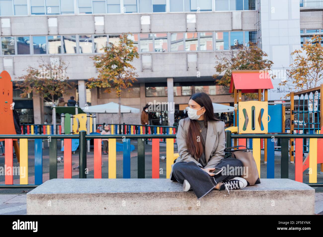 Young beautiful woman using smart phone outdoors with white protective ...