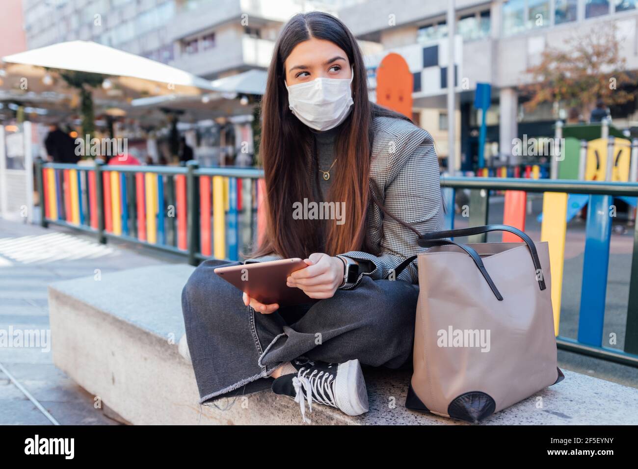 Young beautiful woman using the tablet outdoors with white protective ...