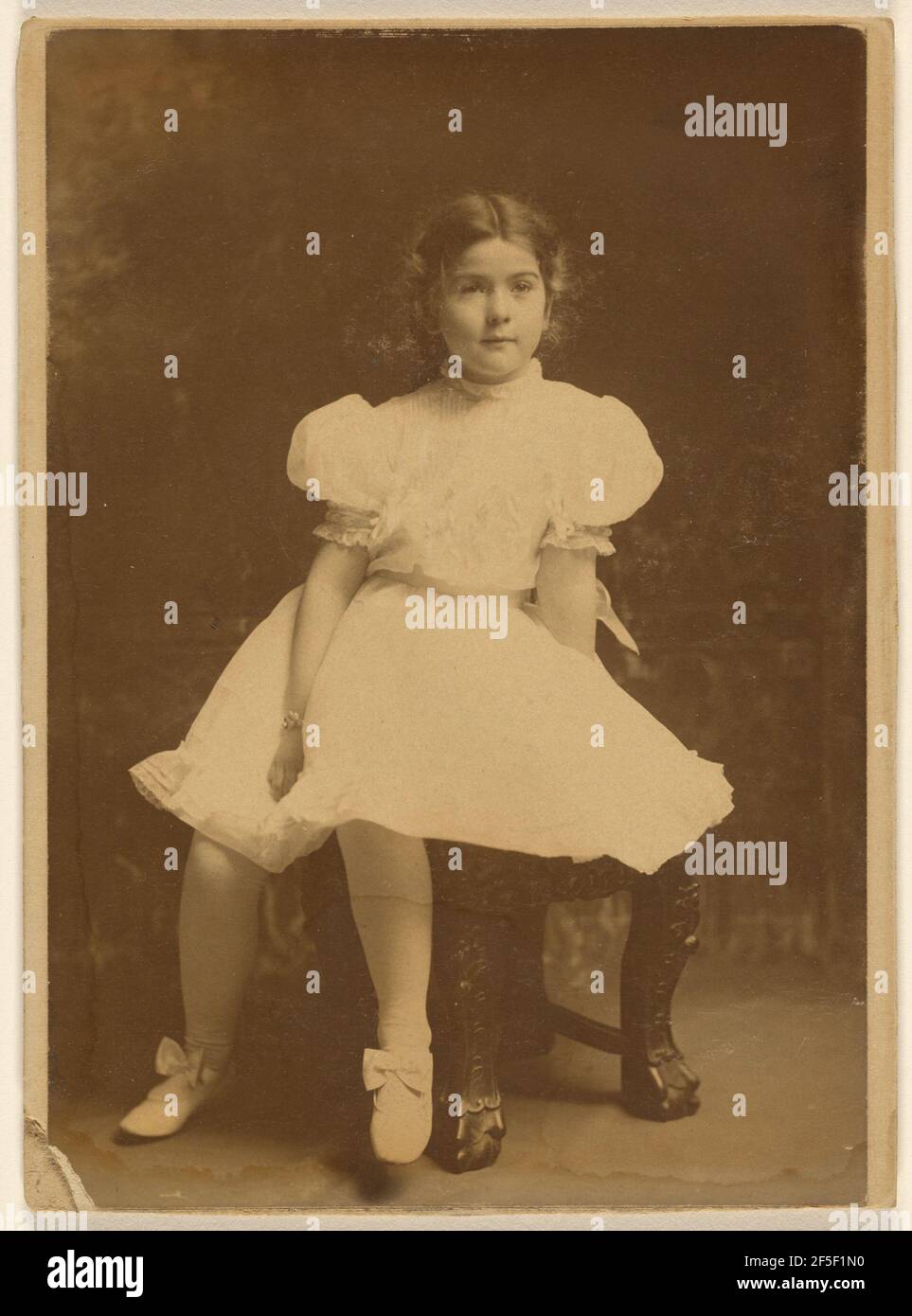 Unidentified young girl in a white dress, seated. Unknown Stock Photo ...