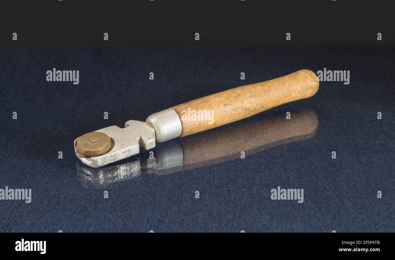 The construction glass cutter is lying on a glass table. Tool on a ...