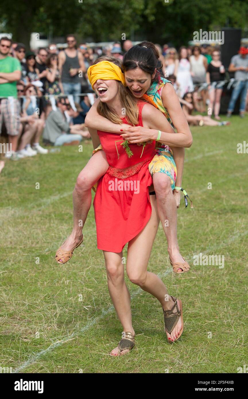 Festival goers compete in the piggy back Grand National on day two of ...