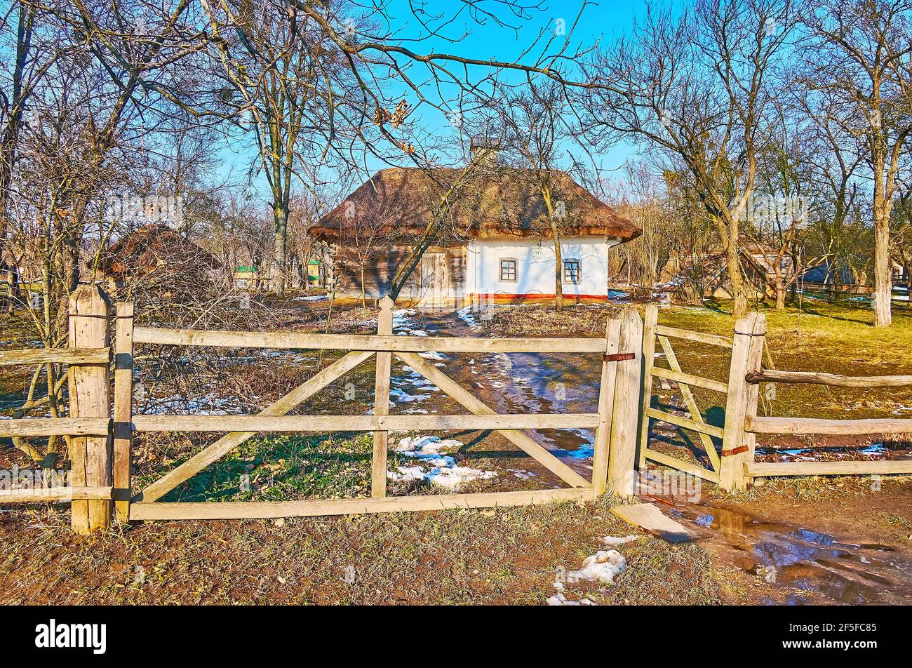 The rural timber gate in front of the wet swampy court with remains of ...