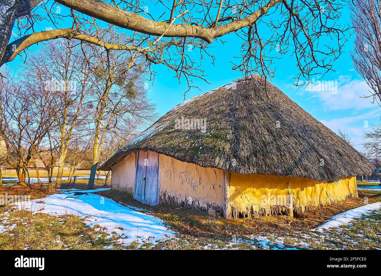 The picturesque rural scene - an old clay barn with straw roof and ...